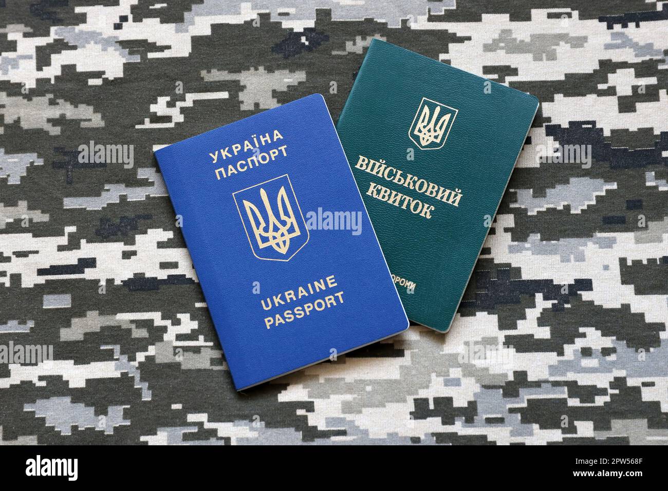 Ukrainian military ID and foreign passport on fabric with texture of ...