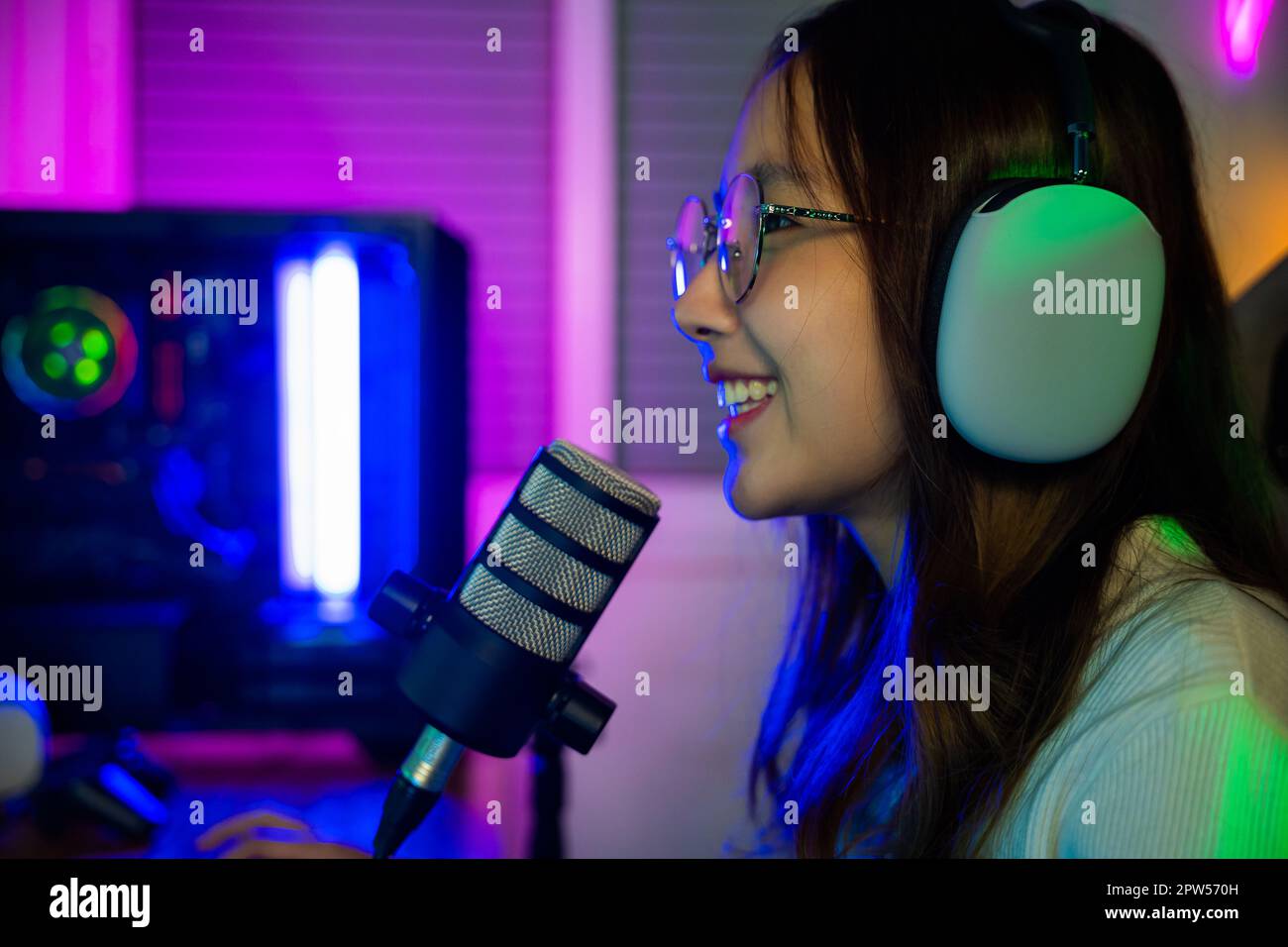 Asian young gamer woman wear headphones playing video games online on ...