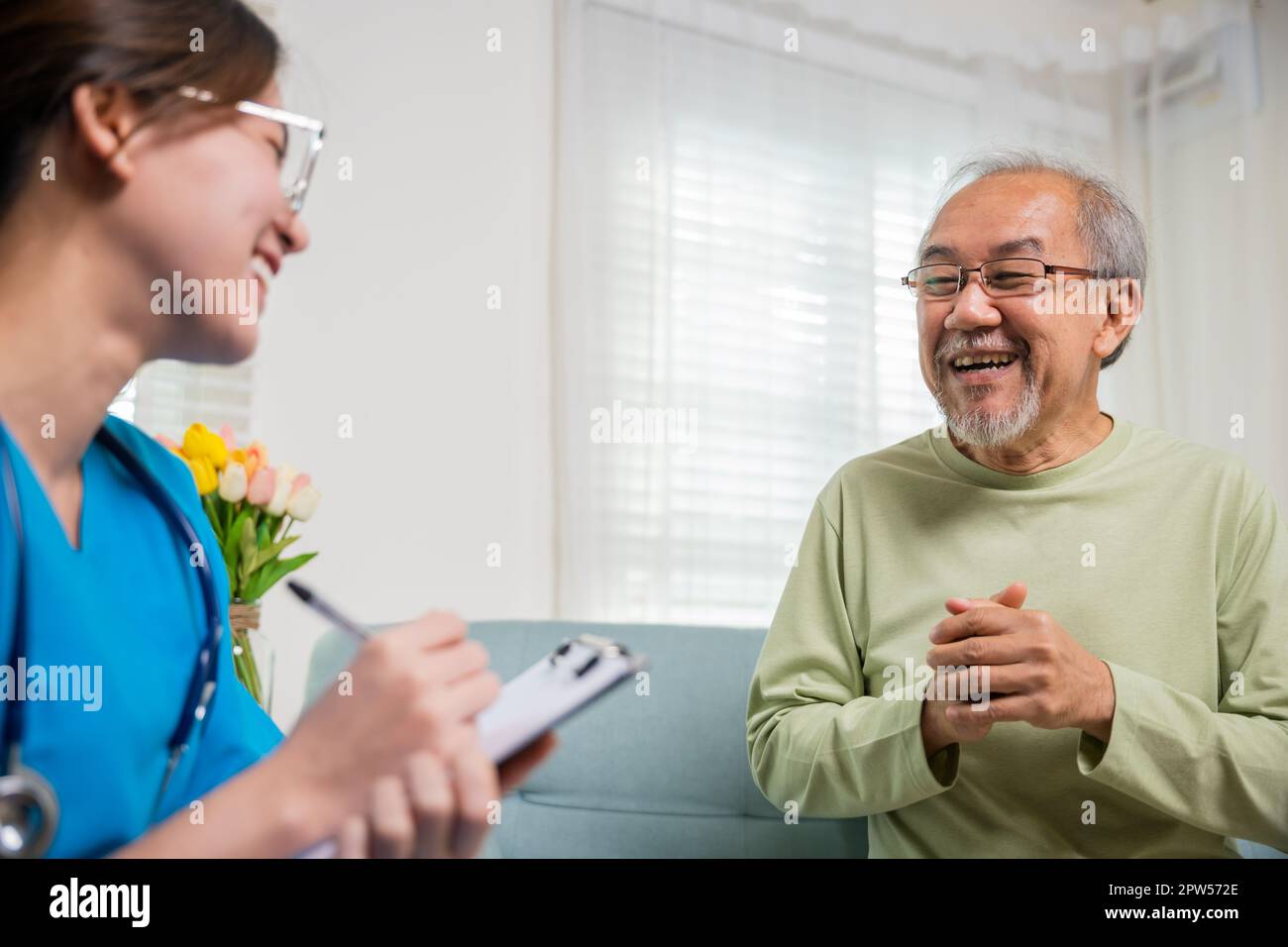 Elderly man takes doctor at home telling about health complaints, Asian ...