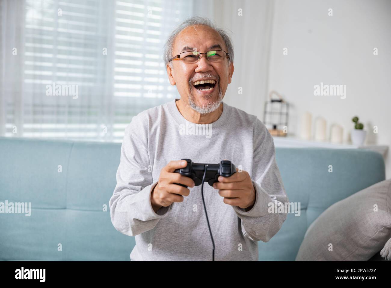 Asian male gamer enjoying online hi-res stock photography and images ...