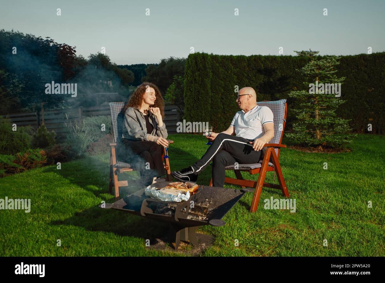 Man woman barbecuing sausages hi-res stock photography and images - Alamy
