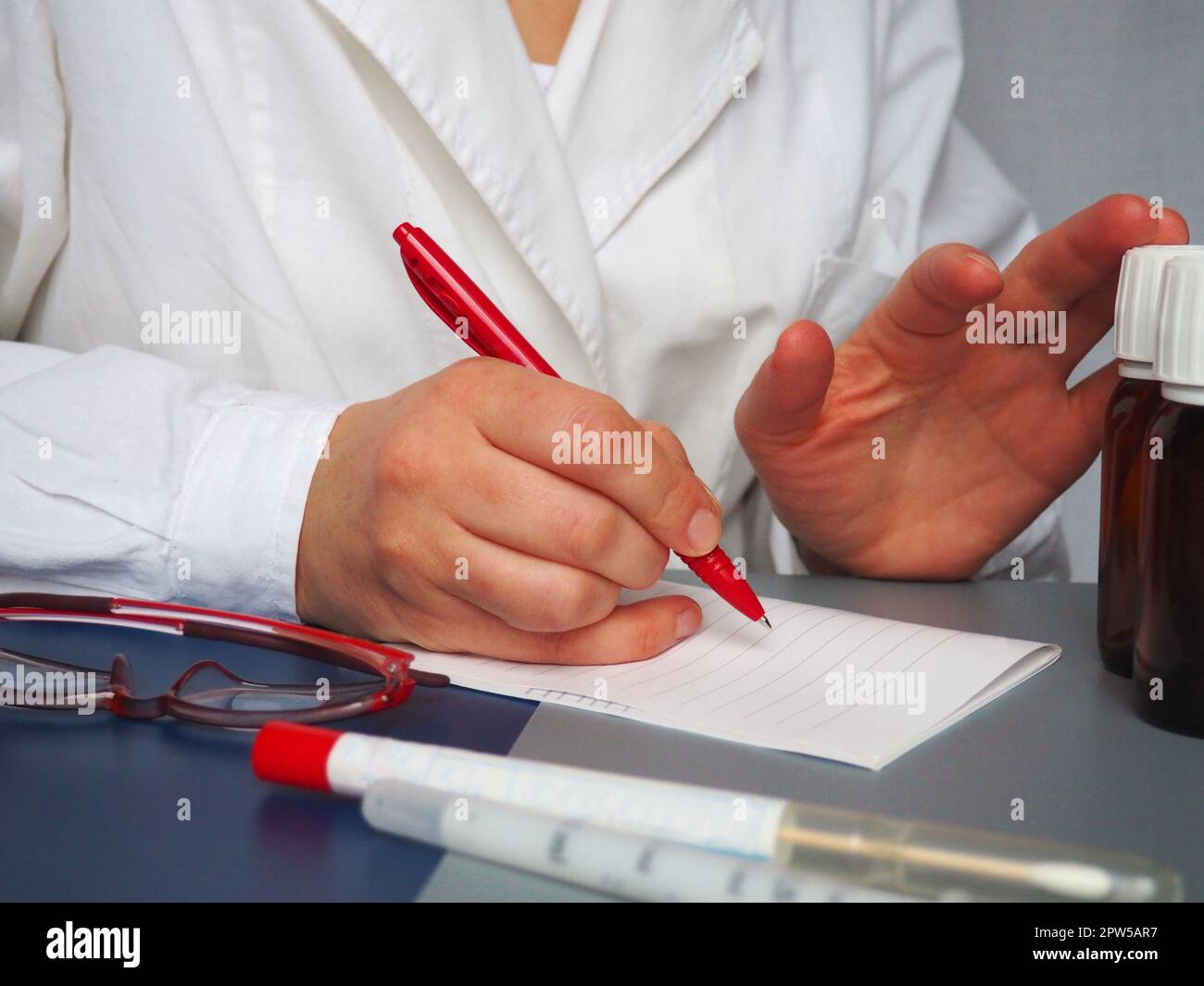 the doctor writes down the prescription on paper and shows with his ...