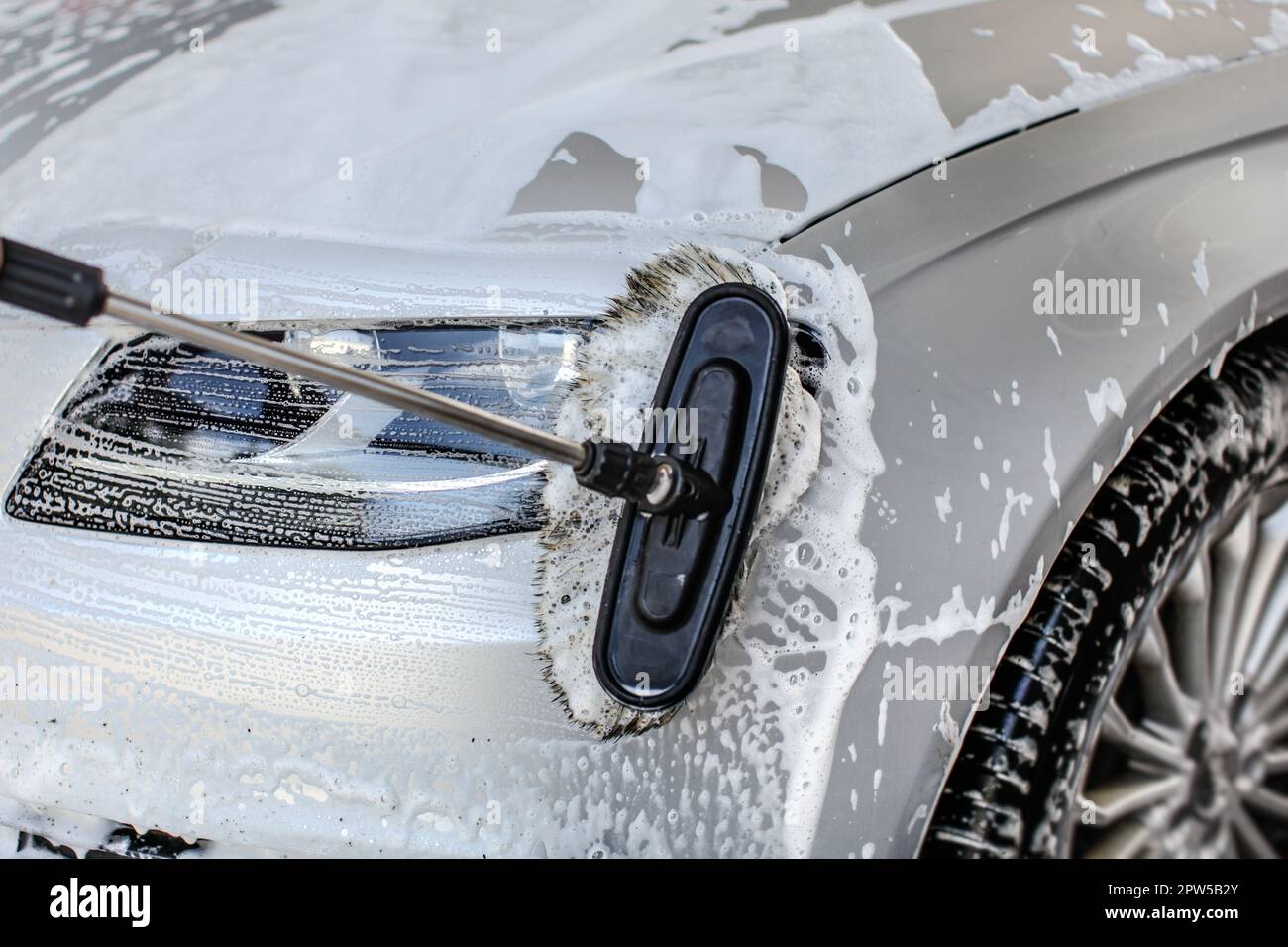 Front light of silver car washed with brush in self serve carwash Stock ...