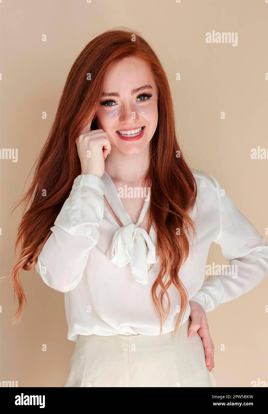 Cheerful young ginger woman with hydrogel eye patches touching head and ...