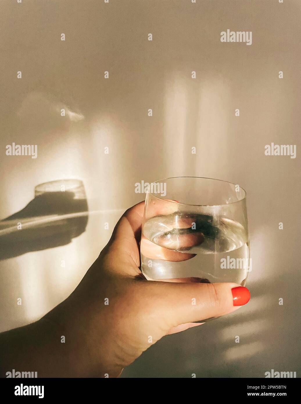 Morning hydration. Female hand holding glass of pure clean mineral ...