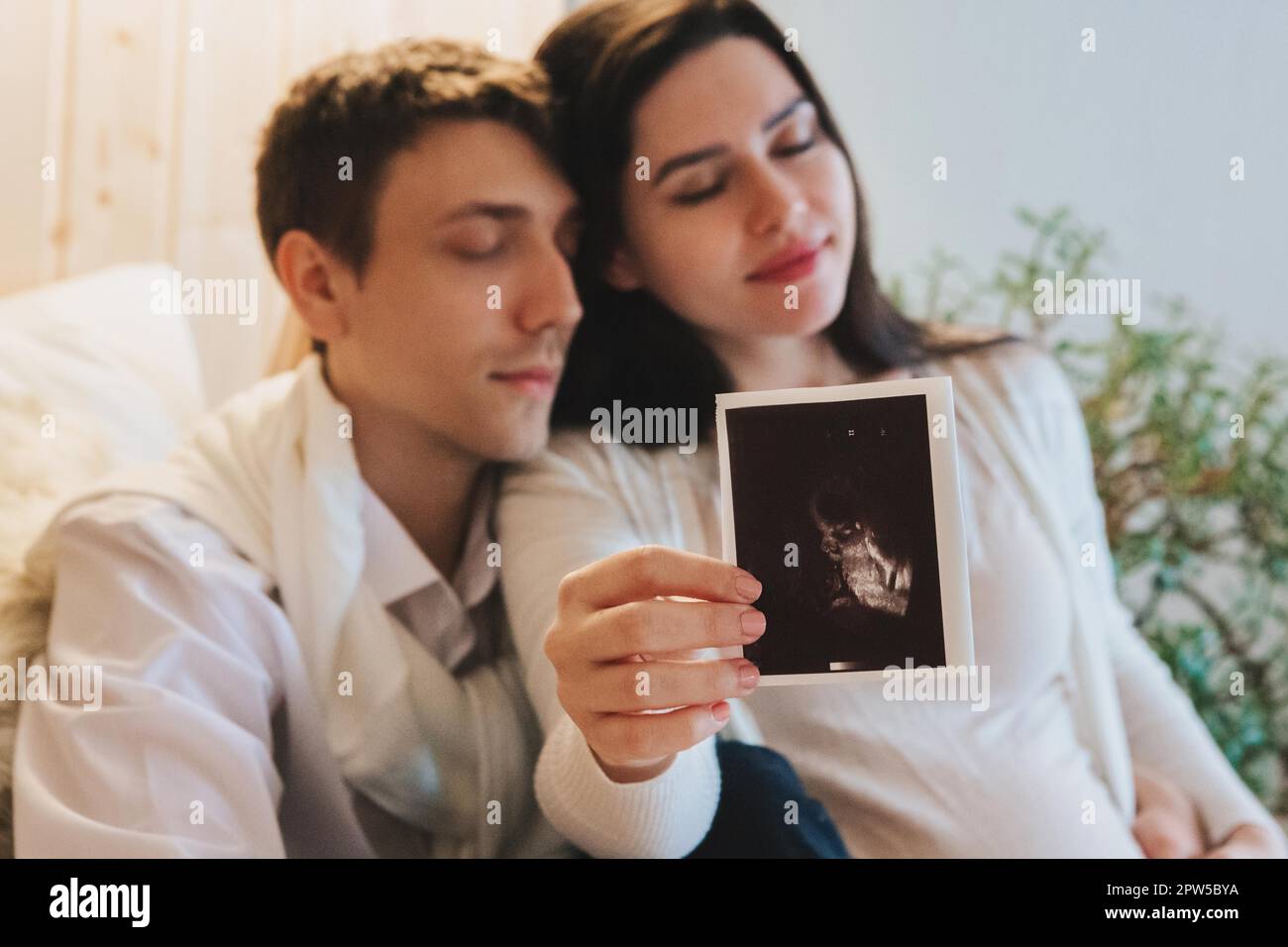 Young happy pregnant woman holding pregnancy ultrasound, showing ...
