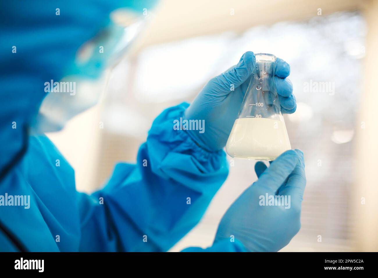 Female lab scientist examining samples in a test tube, working in an ...