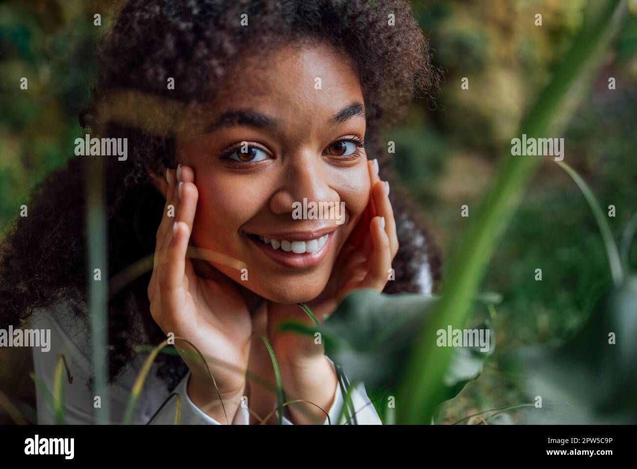 Close up portrait of pretty young african american woman lying on grass ...