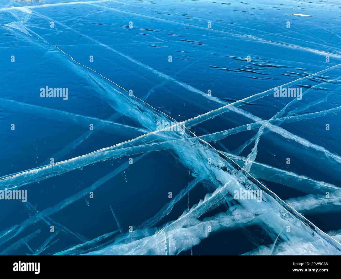 Texture of beautiful blue ice with cracks and air bubbles in the frozen ...