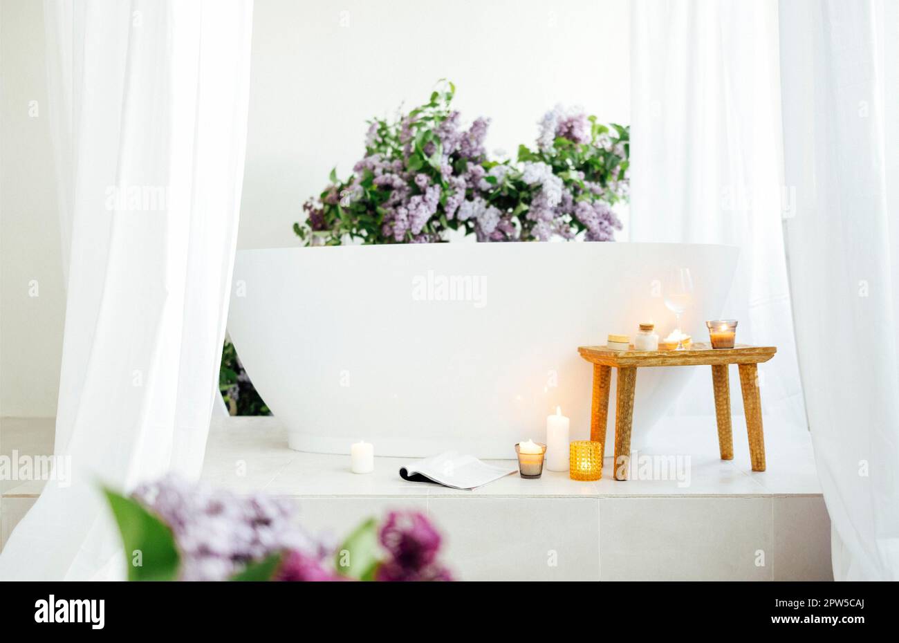 Modern bath room and spa center on the white tub wooden table. Candles ...