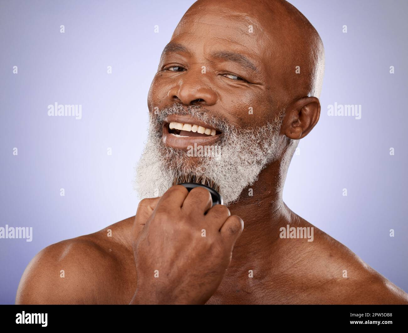 Face, beauty and grooming with a model black man brushing his beard in ...