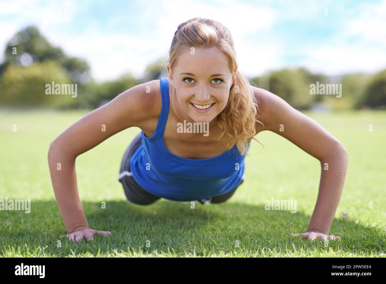 Fit and confident. an attractive young woman doing pushups outside ...