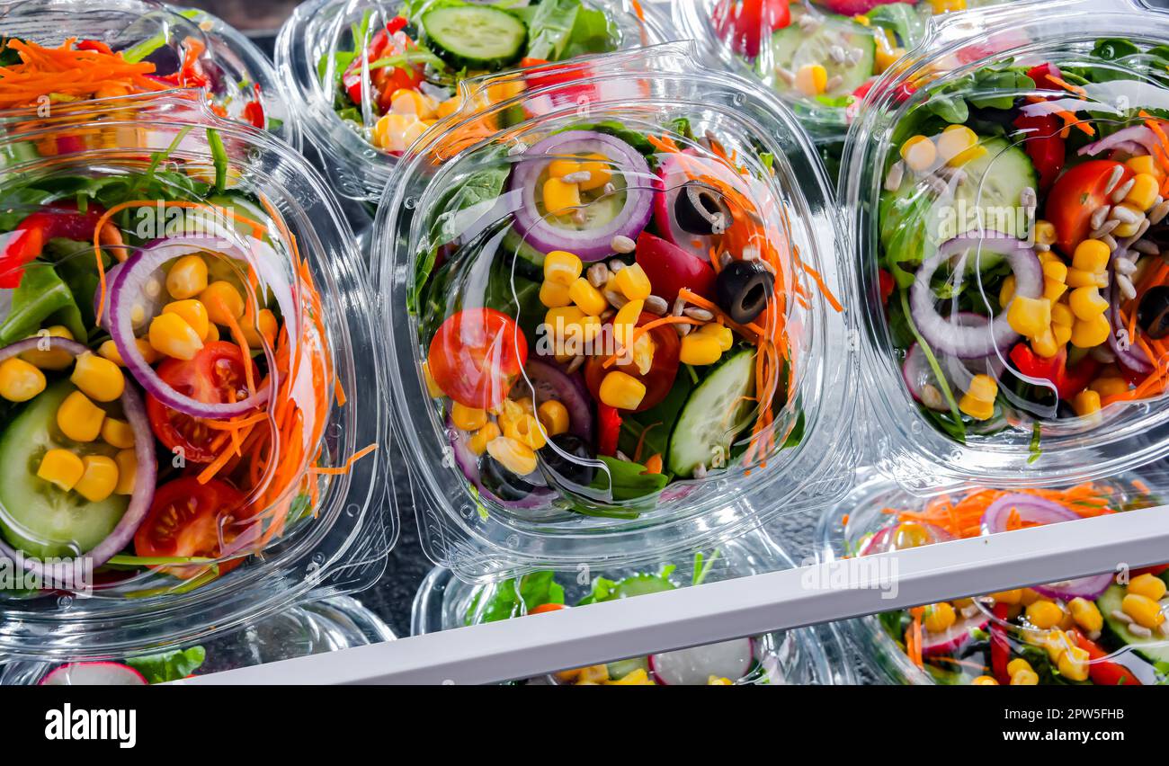 Plastic boxes with pre-packaged vegetable salads, put up for sale in a ...