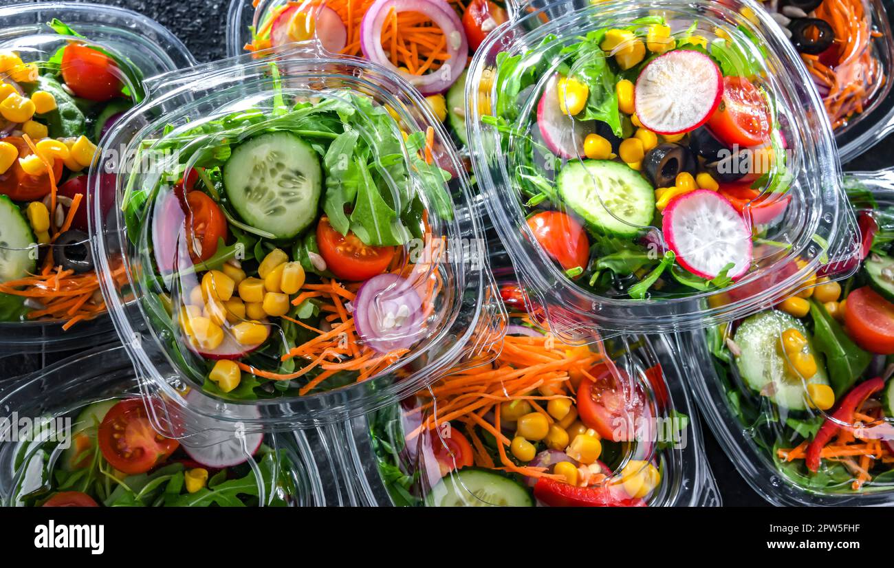 Plastic boxes with pre-packaged vegetable salads, put up for sale in a ...