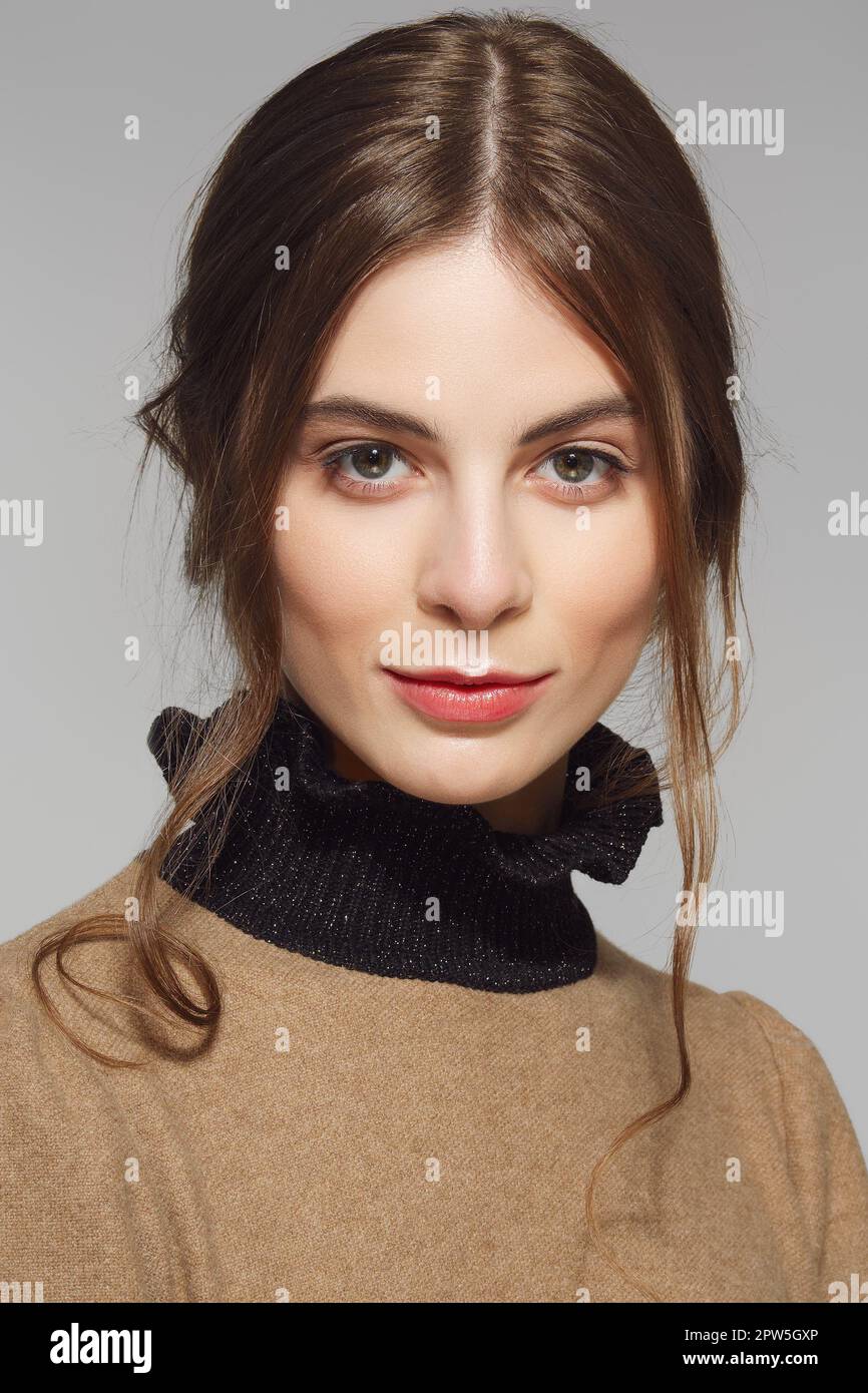 Close up portrait of a young cute woman in warm wool sweater. Clean ...