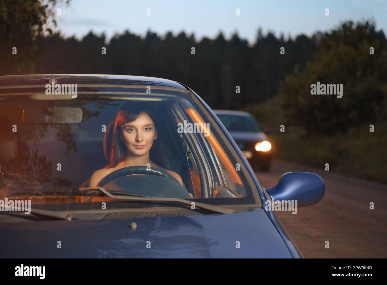 Girl driving the car in the evening on gravel road Stock Photo - Alamy