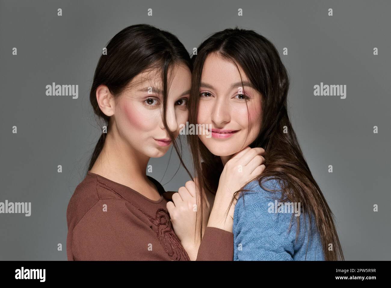 Two girls with smooth dark hair expressing emotions Stock Photo - Alamy