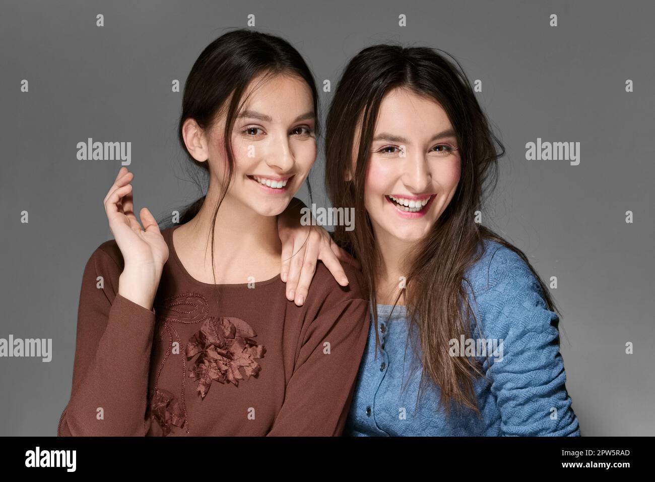 Two girls with smooth dark hair expressing emotions Stock Photo - Alamy