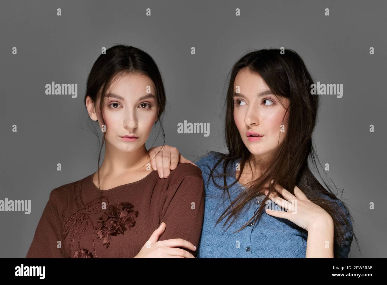 Two girls with smooth dark hair expressing emotions Stock Photo - Alamy