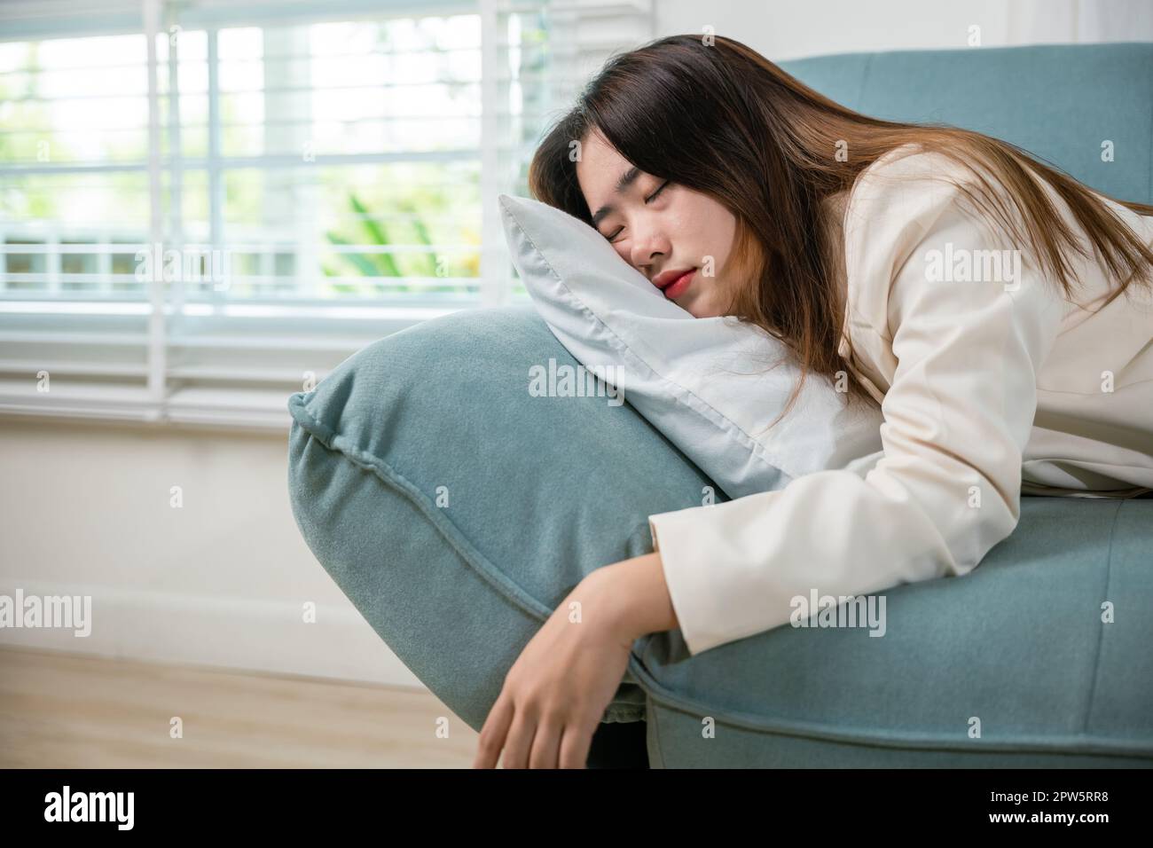 Tired woman sleeping closed eyes on sofa in living room at home after ...