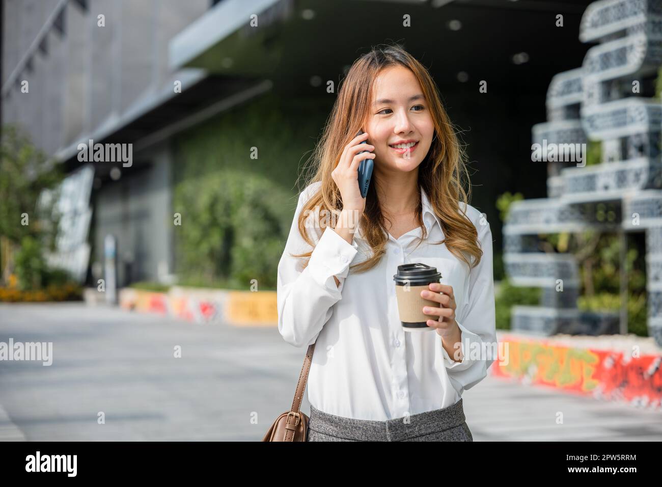 Beautiful woman walking outside in street and calling talking on mobile ...