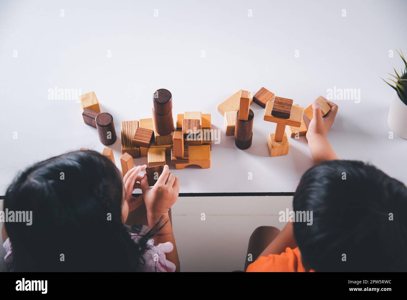 Children boy and girl playing with constructor wooden block building ...