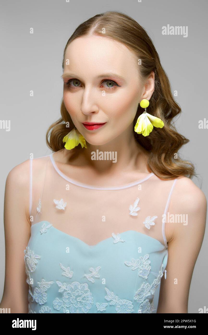 Pretty skeptic girl with big earrings looking tricky Stock Photo - Alamy