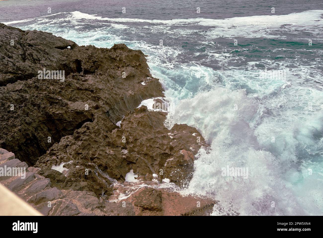 Waves breaking on the shore on a pebble road. water foam, wild waters ...