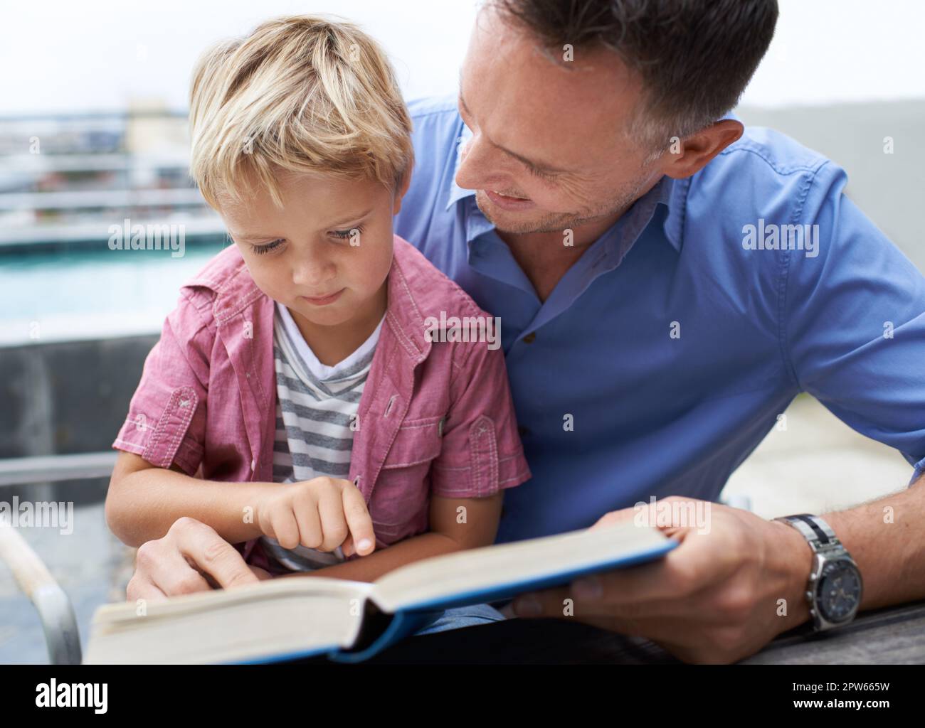 Teaching my son how to read. a father reading to his little boy Stock ...
