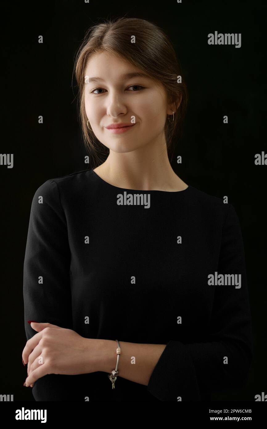 Low key portrait of pretty girl with natural make up in short dress and ...