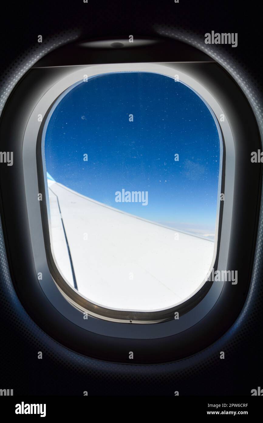 Window of an airplane showing the wing and the blue sky Stock Photo - Alamy