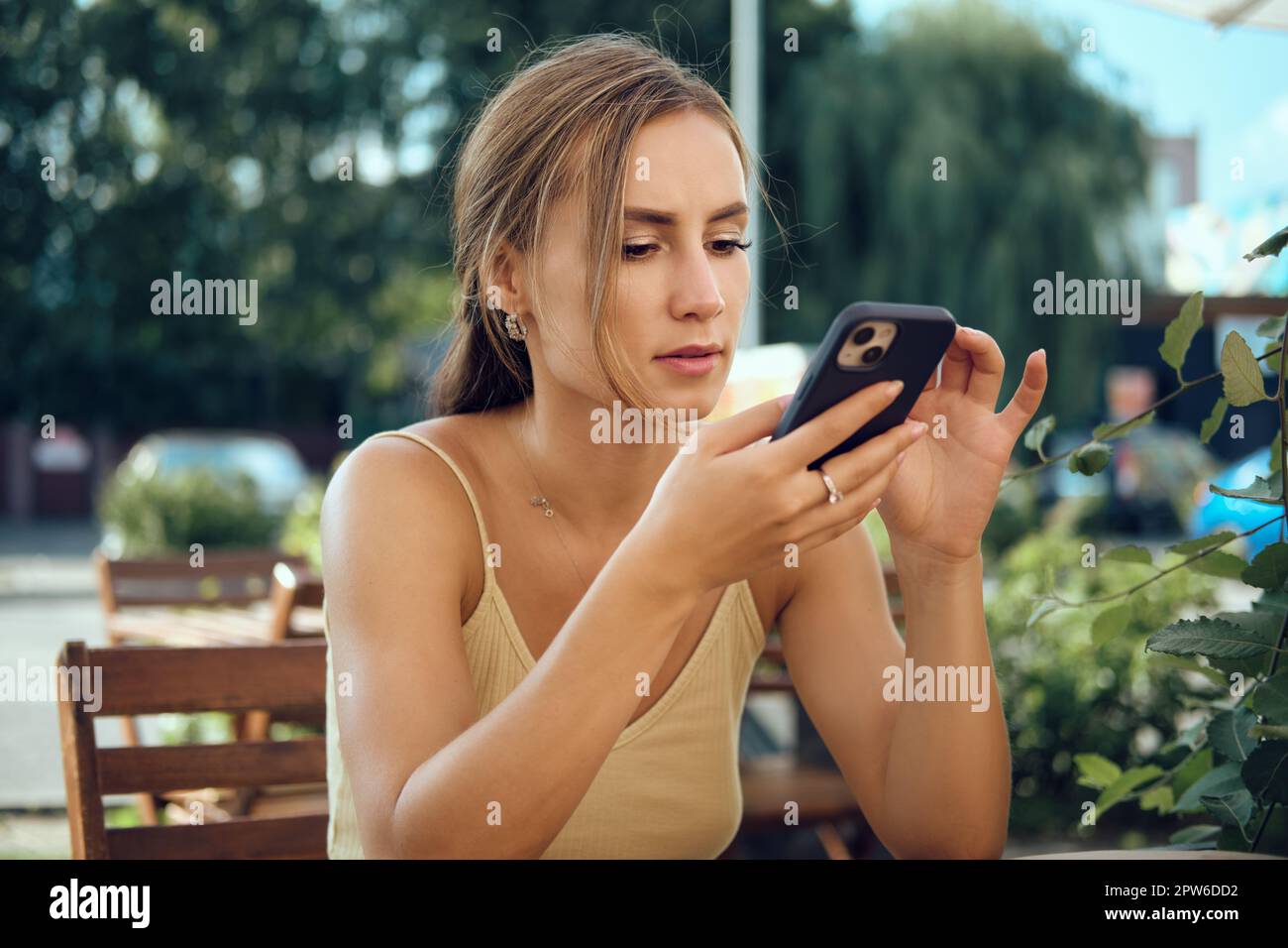 Cute woman scrolling the feed of social network outdoors. Concept of ...