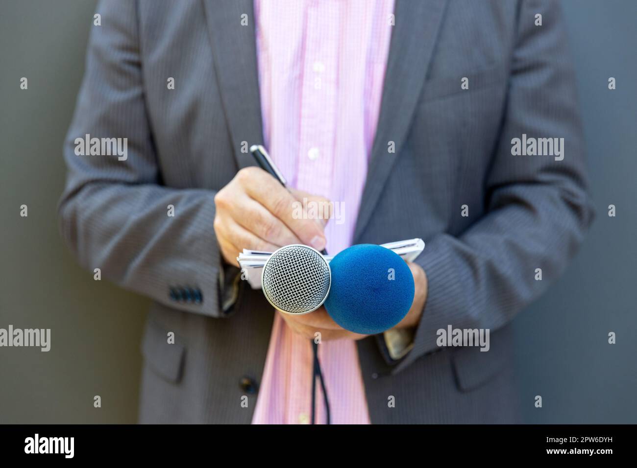Male reporter at press conference or media event, writing notes ...