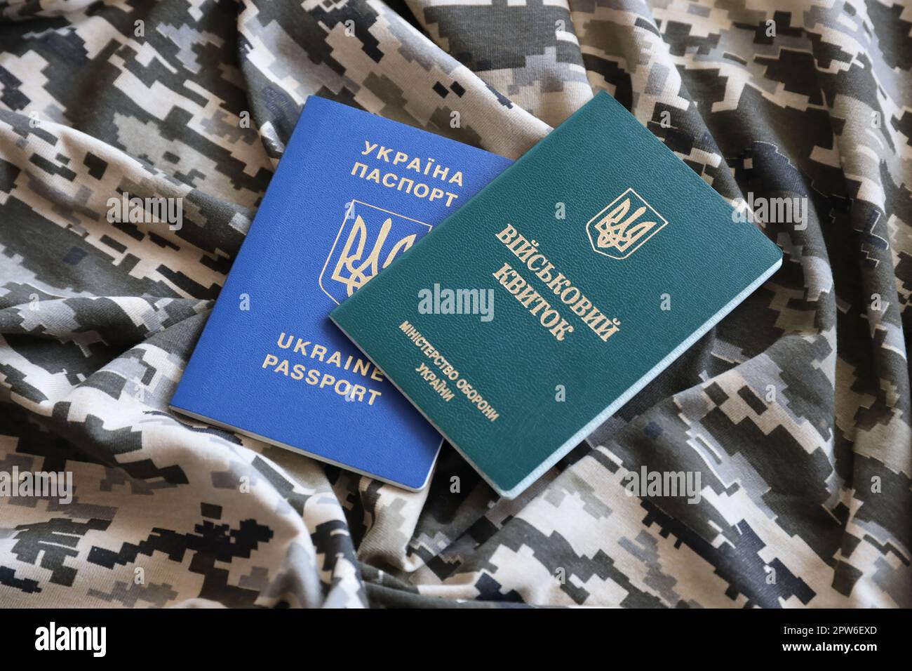 Ukrainian military ID and foreign passport on fabric with texture of ...
