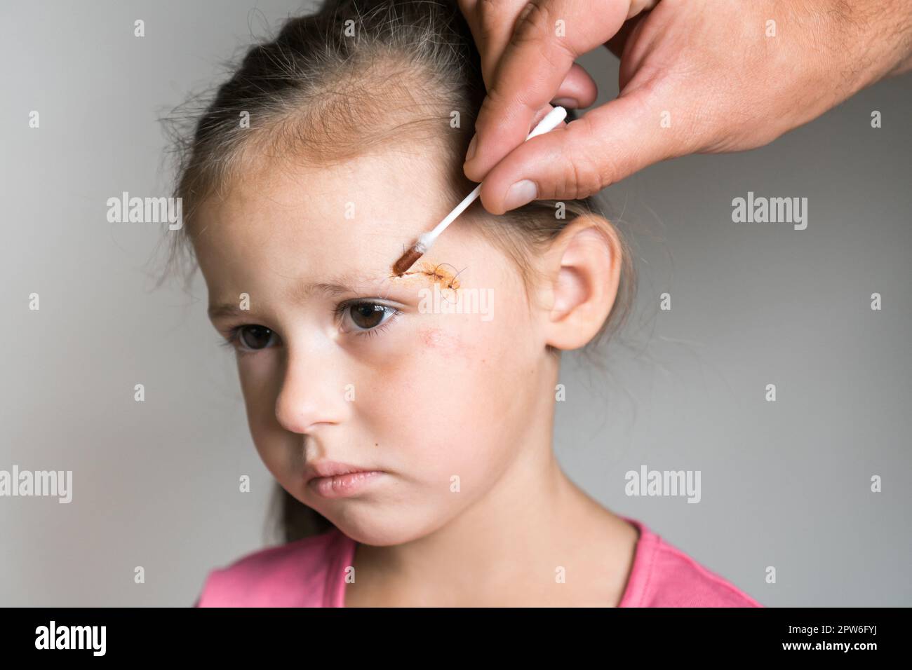 Close up almost crying kid girl face with cropped man hand healing and ...