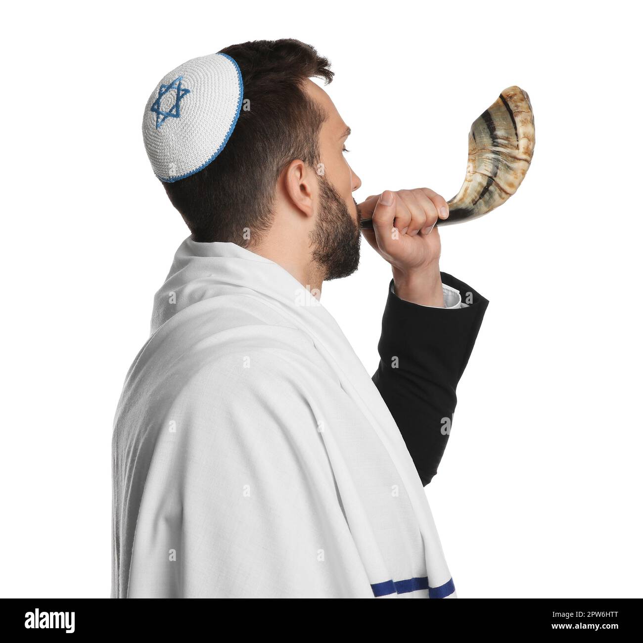 Jewish man with kippah and tallit blowing shofar on white background ...