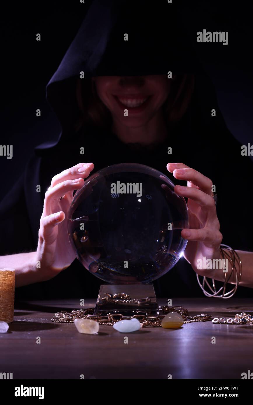 Soothsayer Using Crystal Ball To Predict Future At Table In Darkness