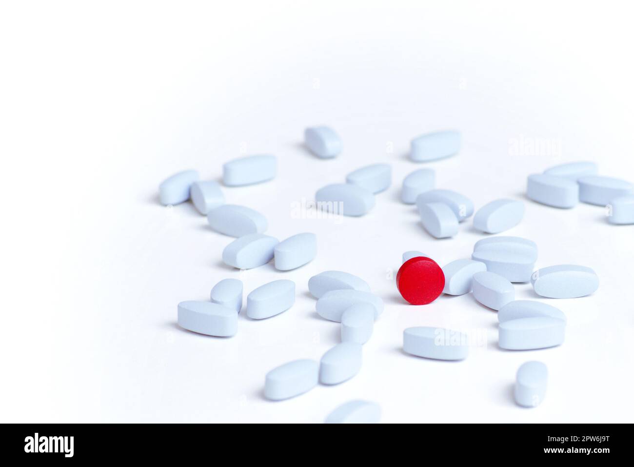 Medication, placebo concept. Single red pill shown prominently among ...