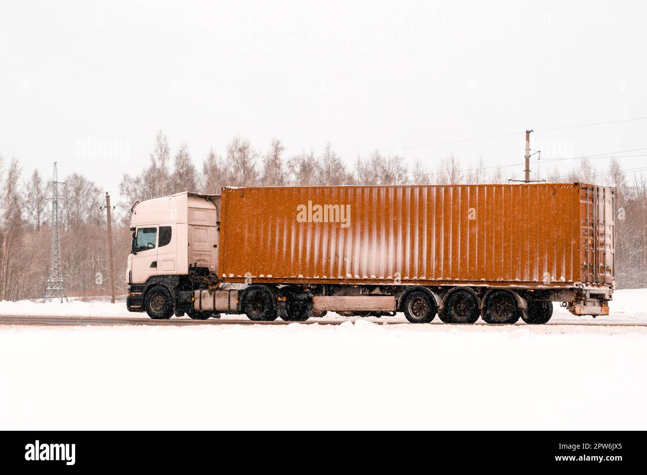 A heavy cargo truck travels with a brown container.Road transport of ...