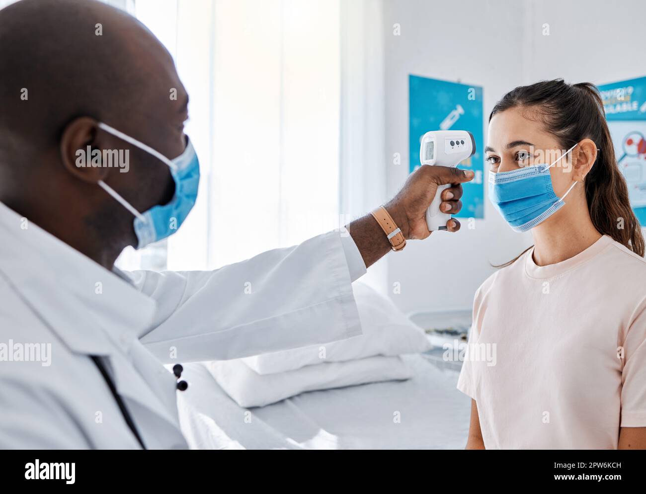 Covid temperature testing at the hospital by a doctor of a female ...