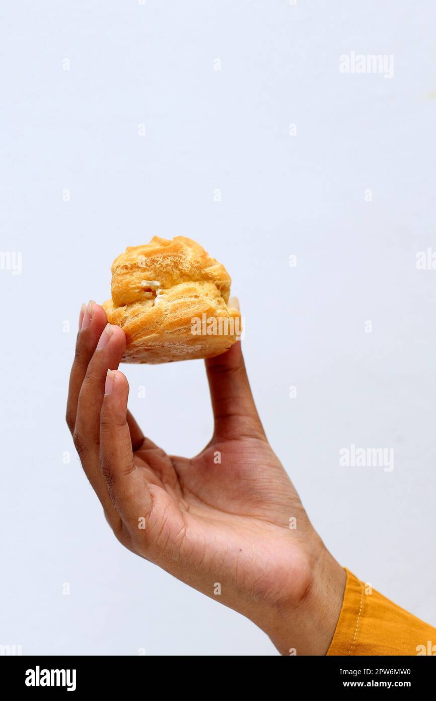 Female Hand Hold Vanilla Custard Soes Choux on White Background. Copy ...