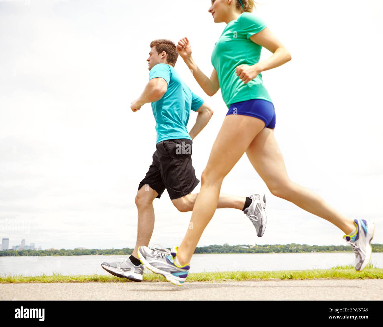 Exercising in peaceful surroundings. Side view of two runners jogging ...