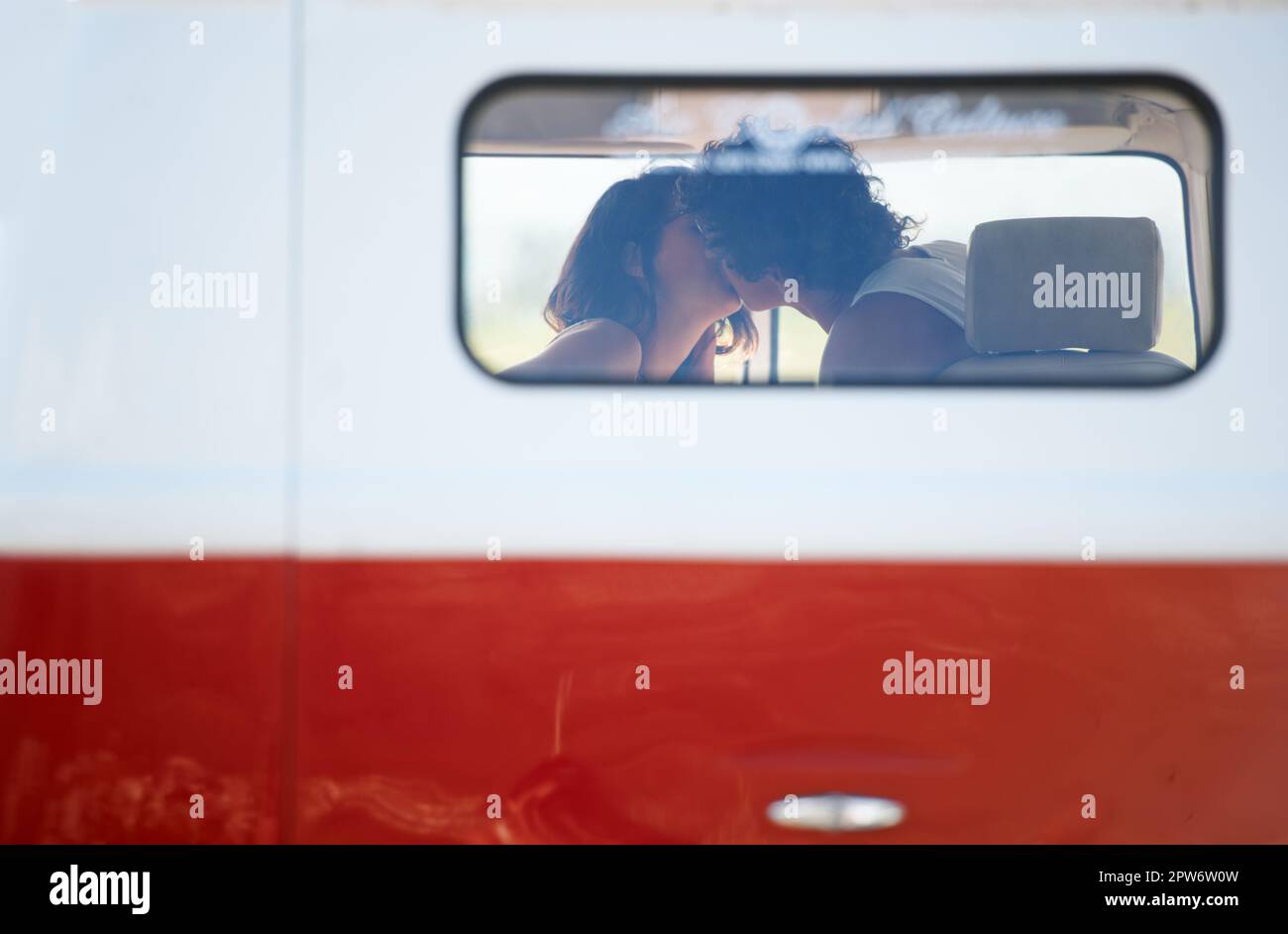 Sneaking A Quick Kiss Window View Of Two Young Lovers Embracing