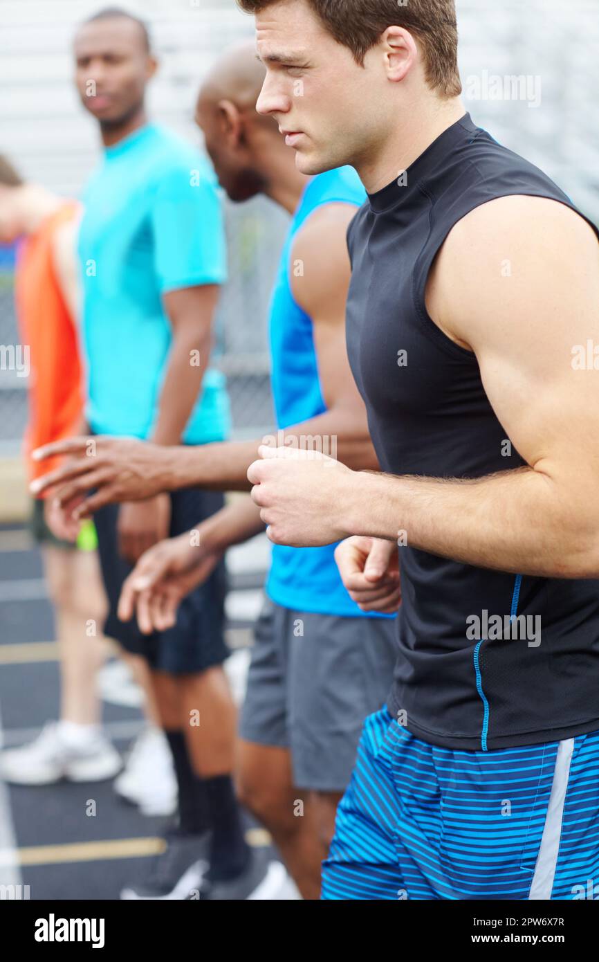 Ready to race. Side view of a line up of male runners at the starting ...