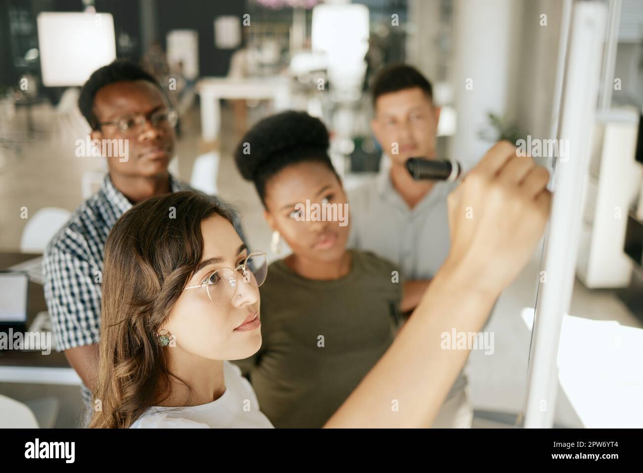 Mixed race coach mentor writing on board explaining idea and thoughts ...