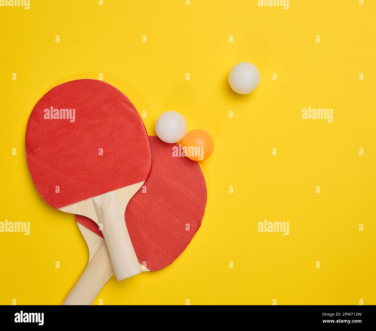Pair of wooden tennis rackets for ping pong and plastic balls on a ...