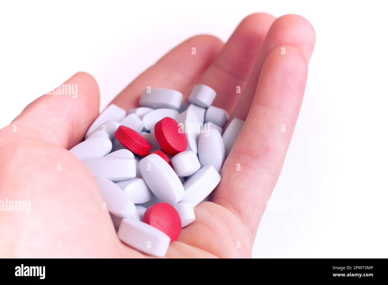 Drug abuse, self medication, placebo concept. Handful of red and blue ...