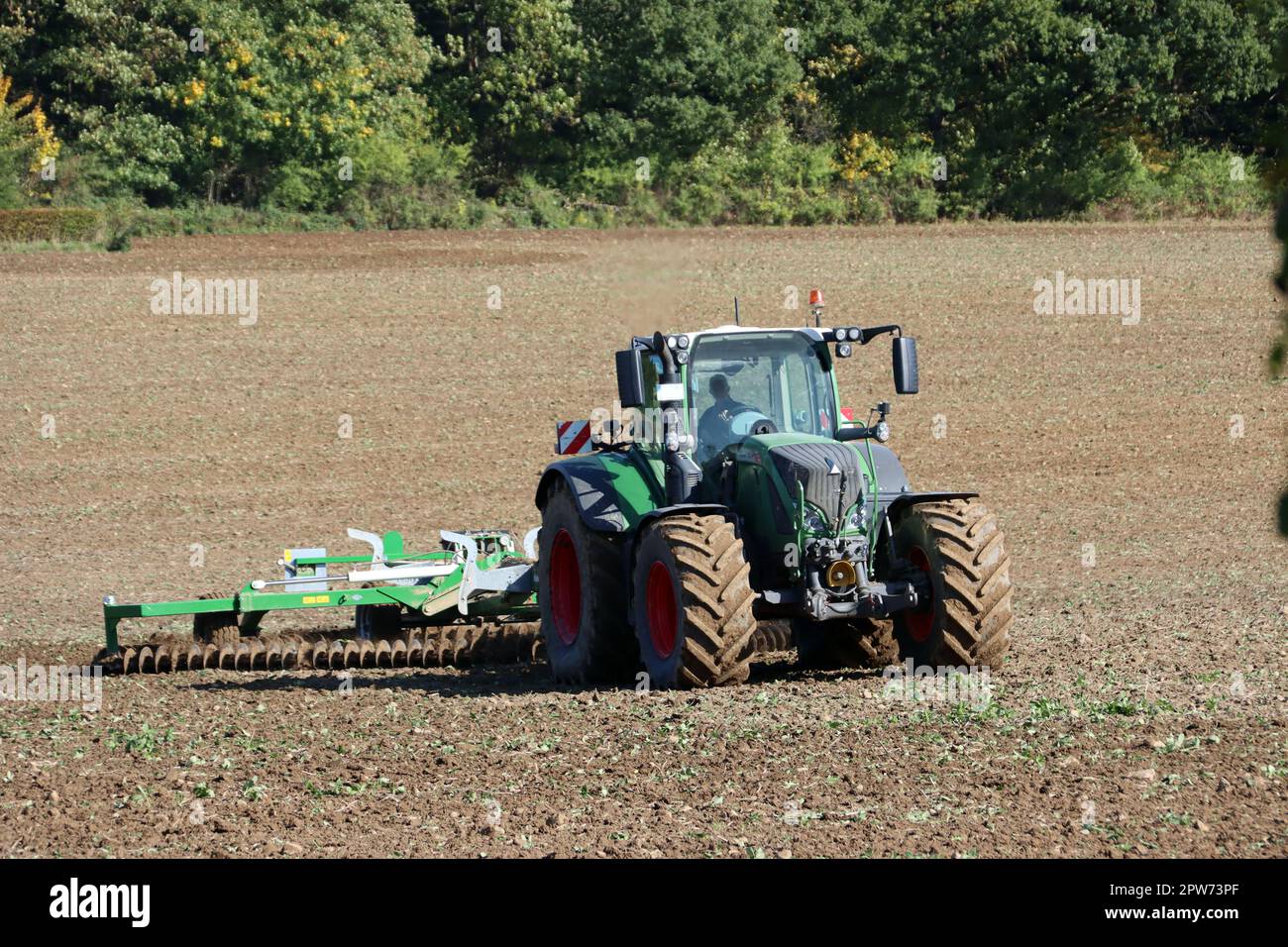Landwirt eggt mit seinem Traktor ein Feld nahe der Sababurg, Hessen ...