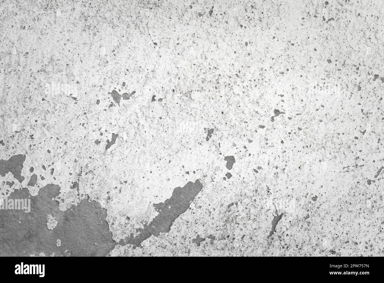 Weathered white wall. Peeling paint shows concrete underneath. Detail ...