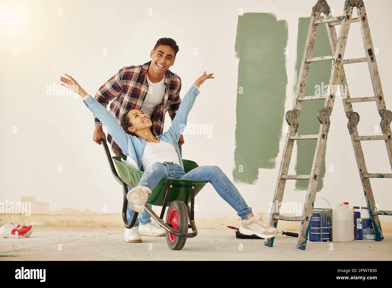 Love, teamwork and renovation, couple paint a wall in a house green ...